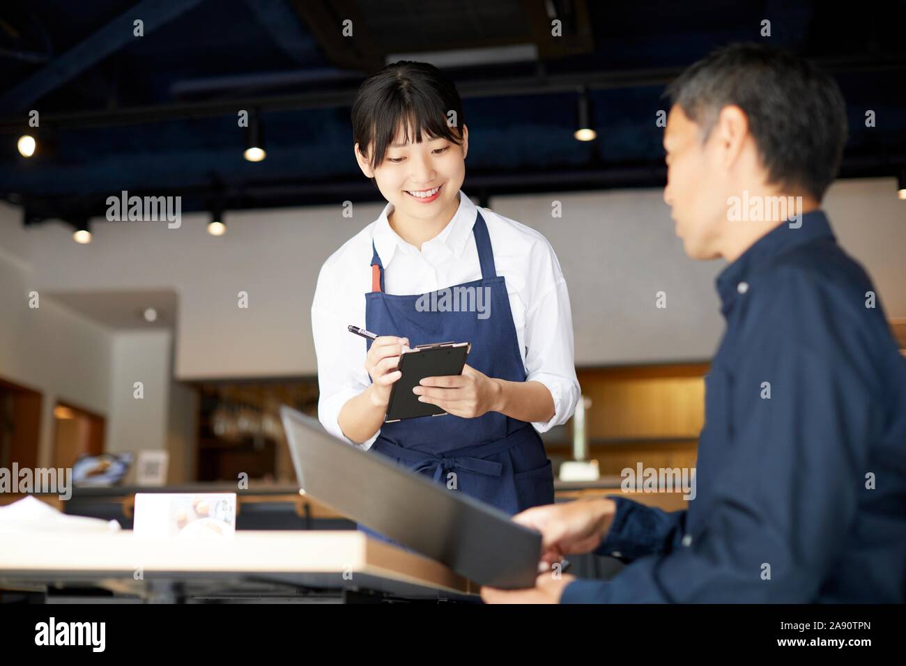 Young Japanese woman working at a restaurant Stock Photo - Alamy
