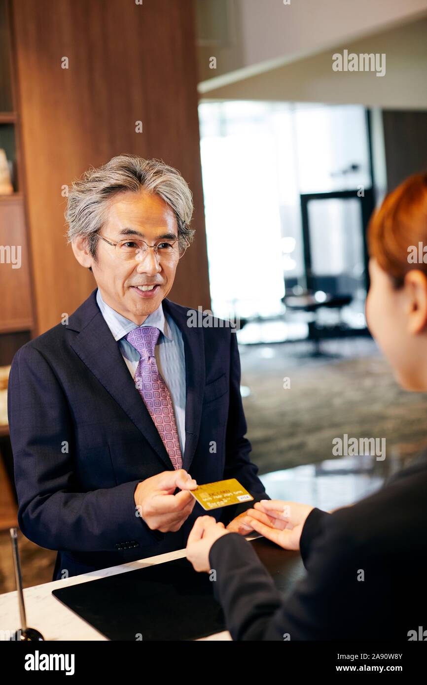 Senior businessman checking in at hotel Stock Photo - Alamy