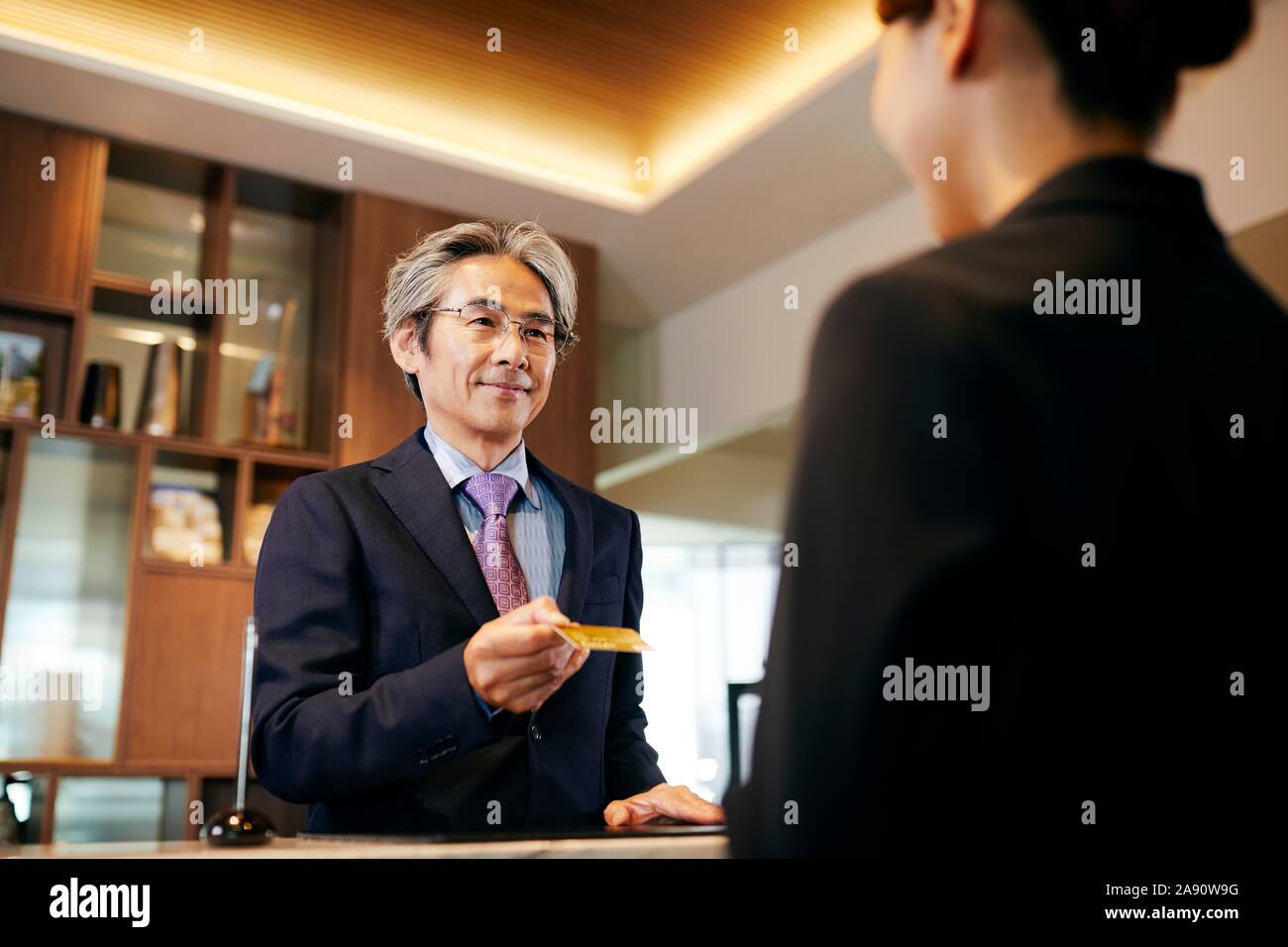 Senior businessman checking in at hotel Stock Photo - Alamy