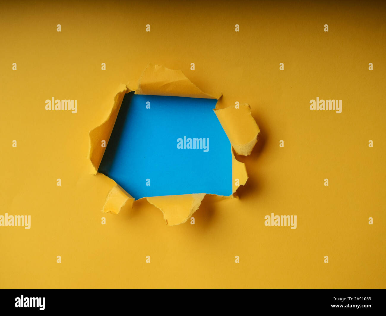 Small paper hole with torn sides over yellow background for your text ...