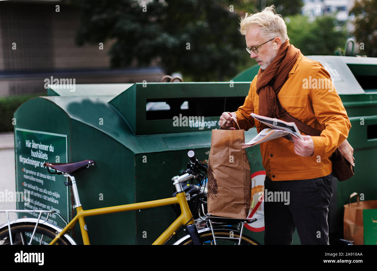 Man putting garbage into recycling bin Stock Photo - Alamy