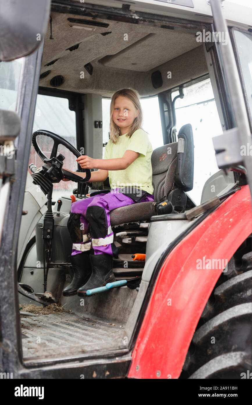 Girl sitting in tractor Stock Photo - Alamy