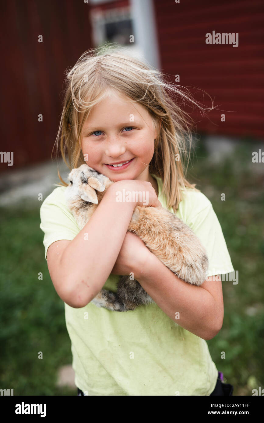 Girl holding rabbit Stock Photo - Alamy