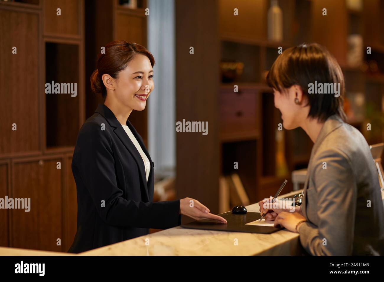 Young woman checking in at hotel Stock Photo - Alamy