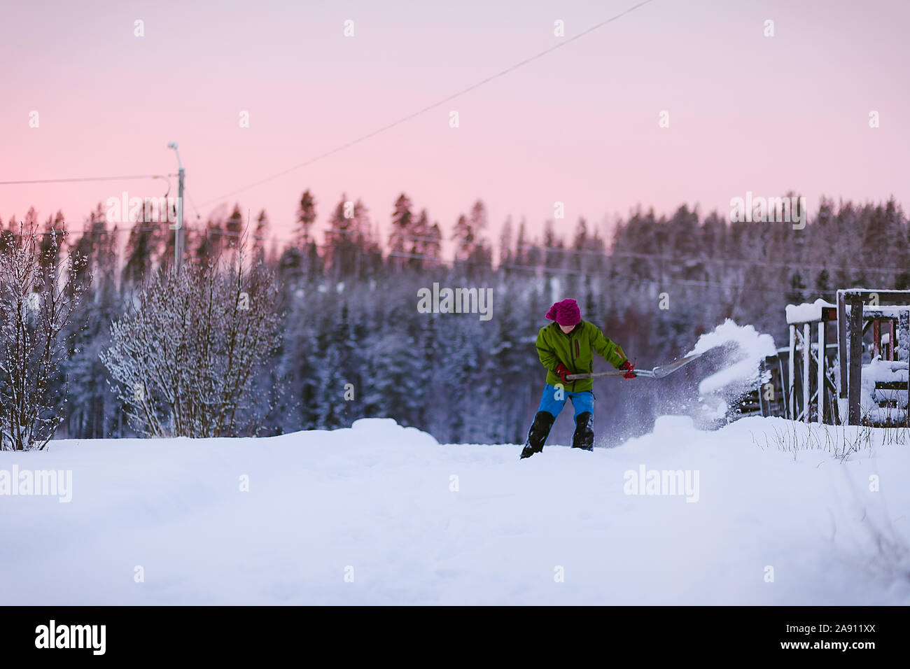Girl digging in snow Stock Photo - Alamy