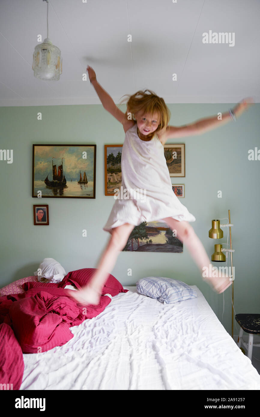 Girl jumping on bed Stock Photo - Alamy