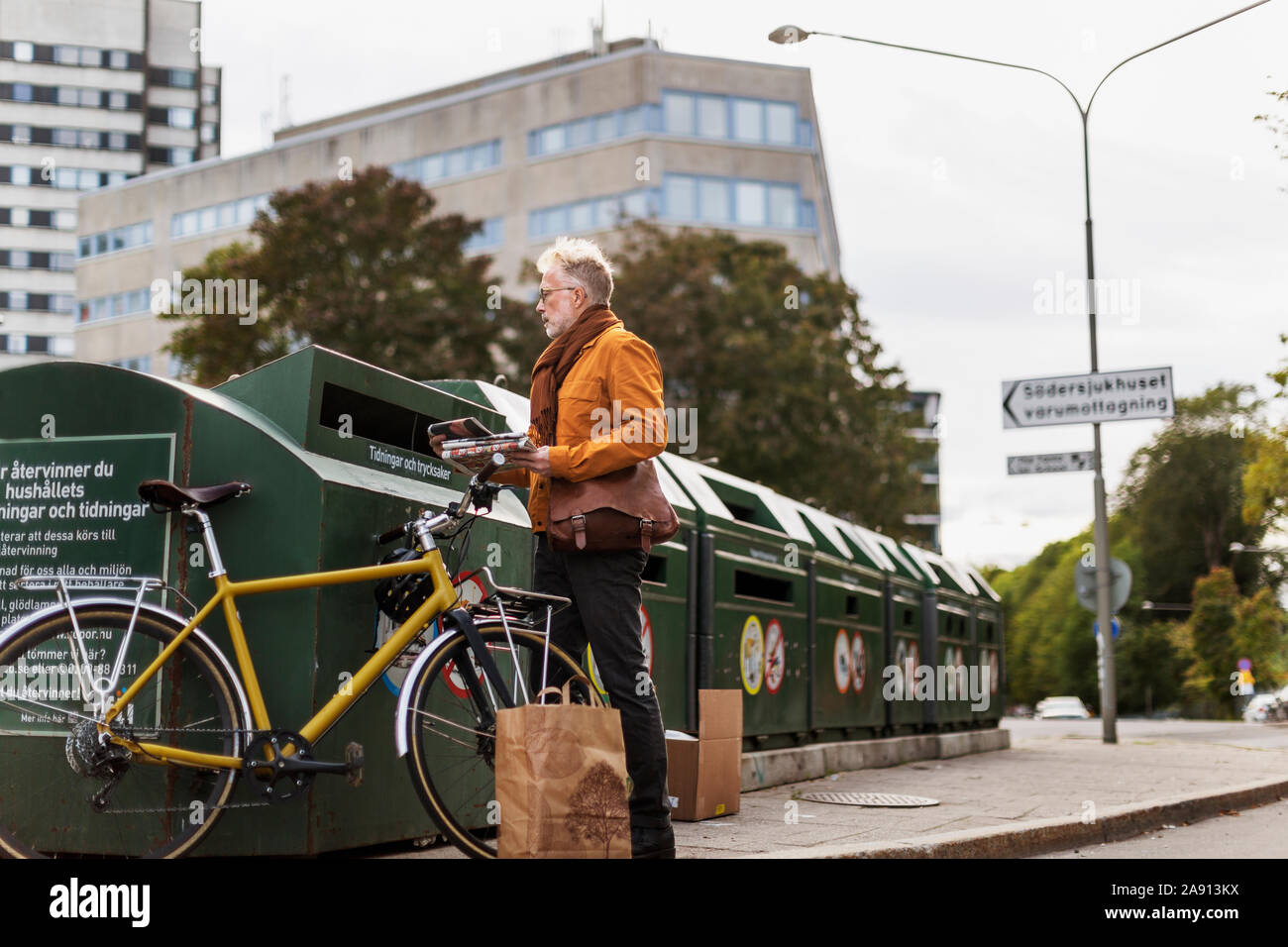 Man putting garbage into recycling bin Stock Photo - Alamy
