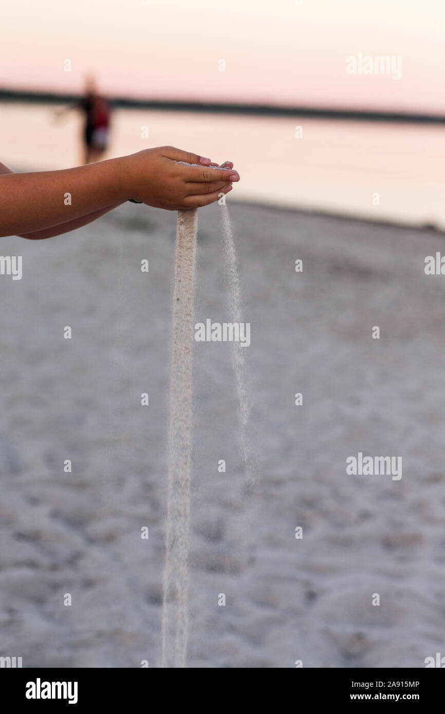 Sand falling through hands Stock Photo - Alamy
