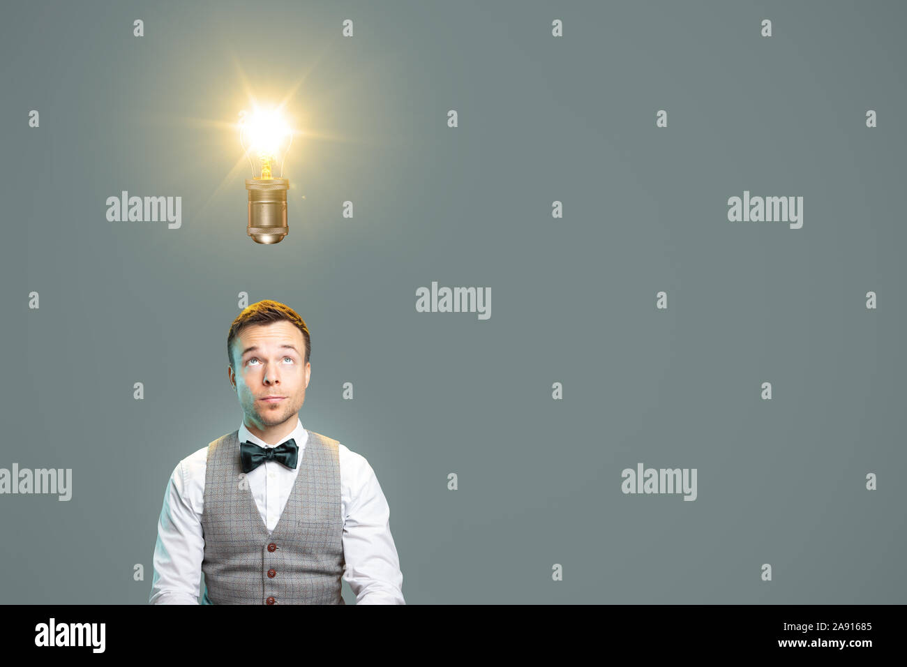 Man looking towards a light bulb above his head Stock Photo - Alamy