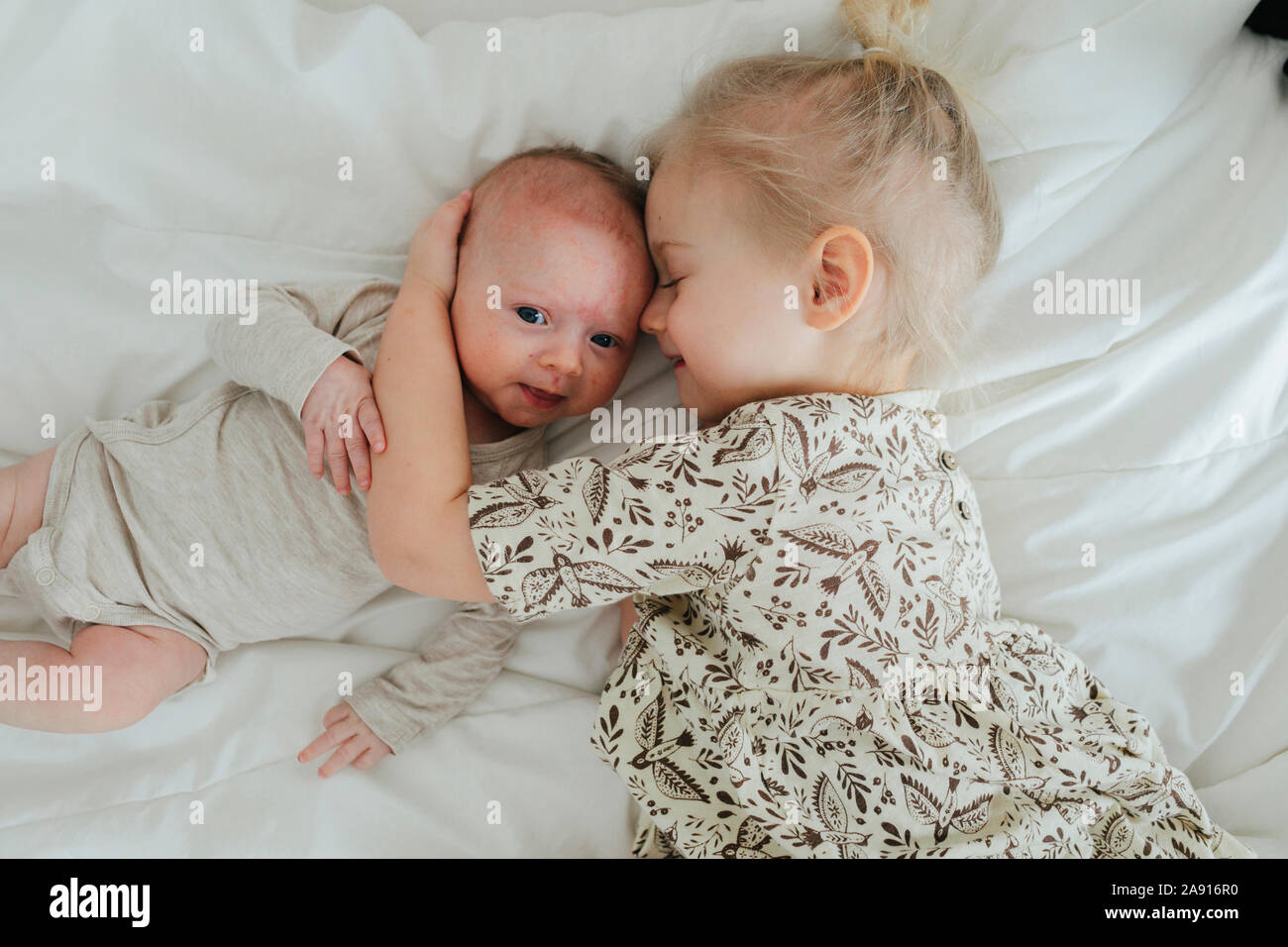 Girl hugging baby sibling Stock Photo - Alamy