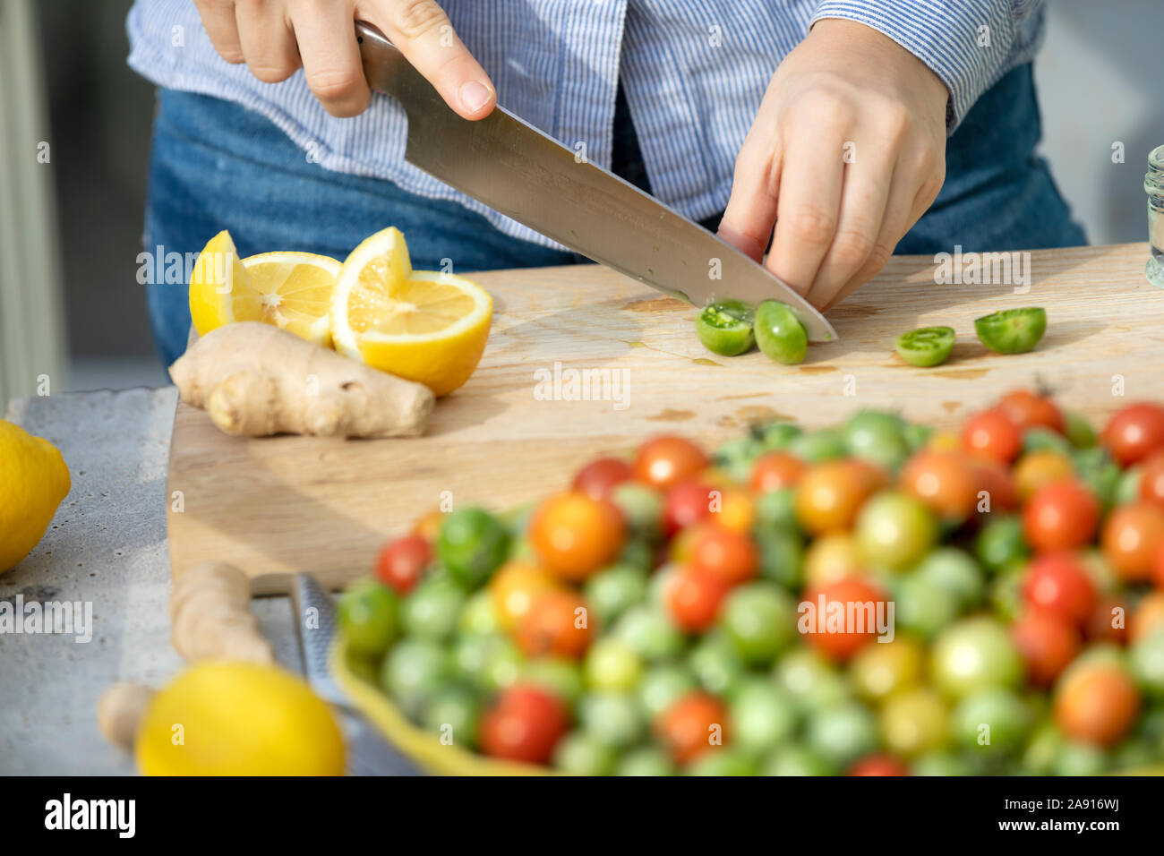 Hand cutting cherry tomatoes hi-res stock photography and images - Alamy