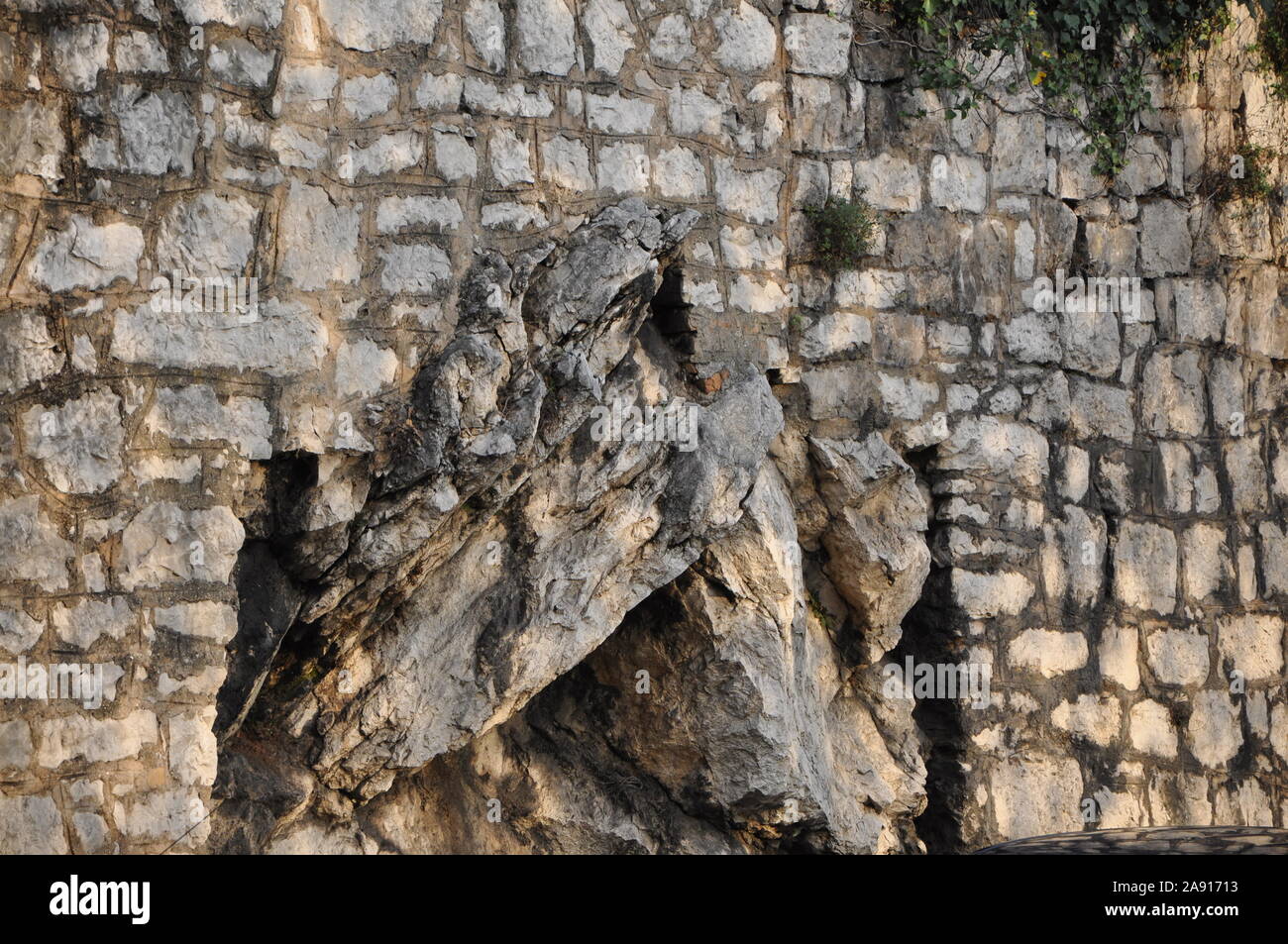 high stone wall resembling interesting shape Stock Photo - Alamy