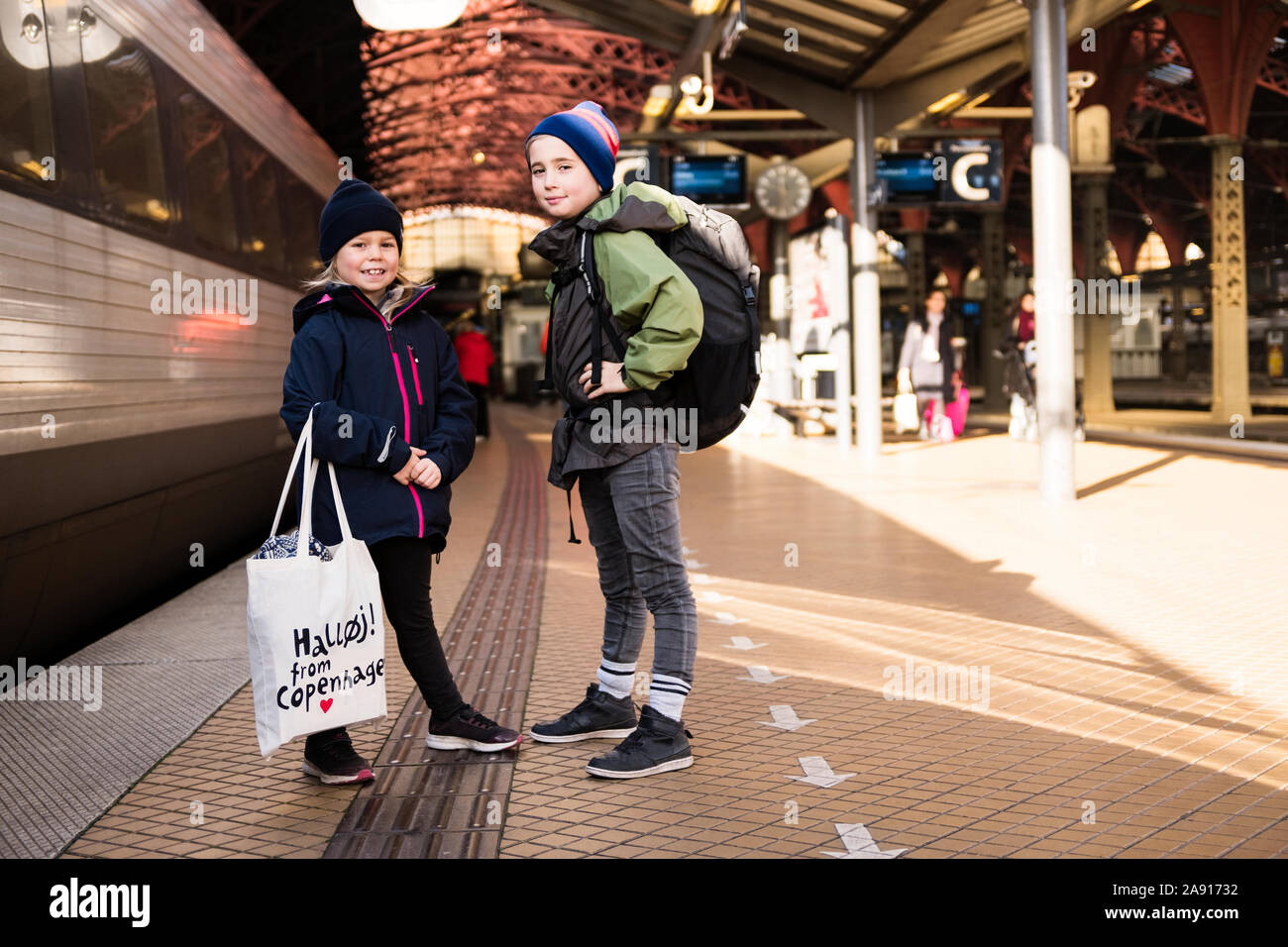 Brother and sister on train platform Stock Photo - Alamy