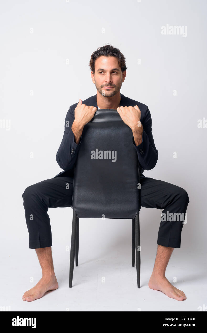 Full body shot of handsome Hispanic businessman looking away while ...