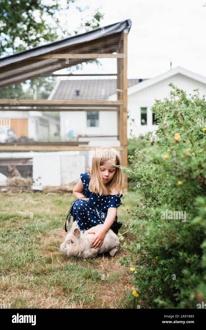Girl playing with rabbit Stock Photo - Alamy
