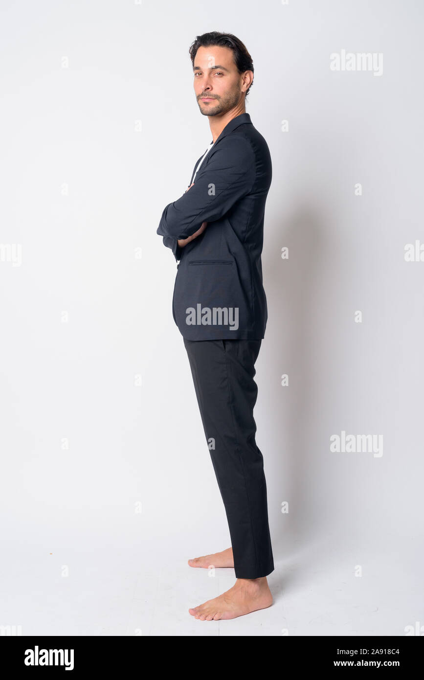Full body shot profile view of Hispanic businessman looking at camera ...
