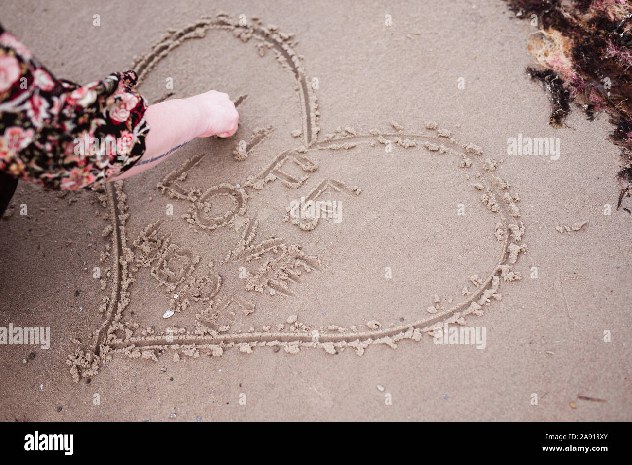 Hand writing on sand Stock Photo - Alamy