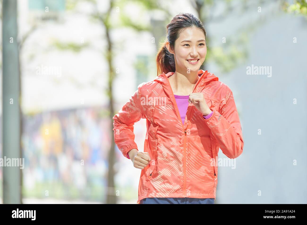 Young Japanese woman running downtown Tokyo Stock Photo - Alamy