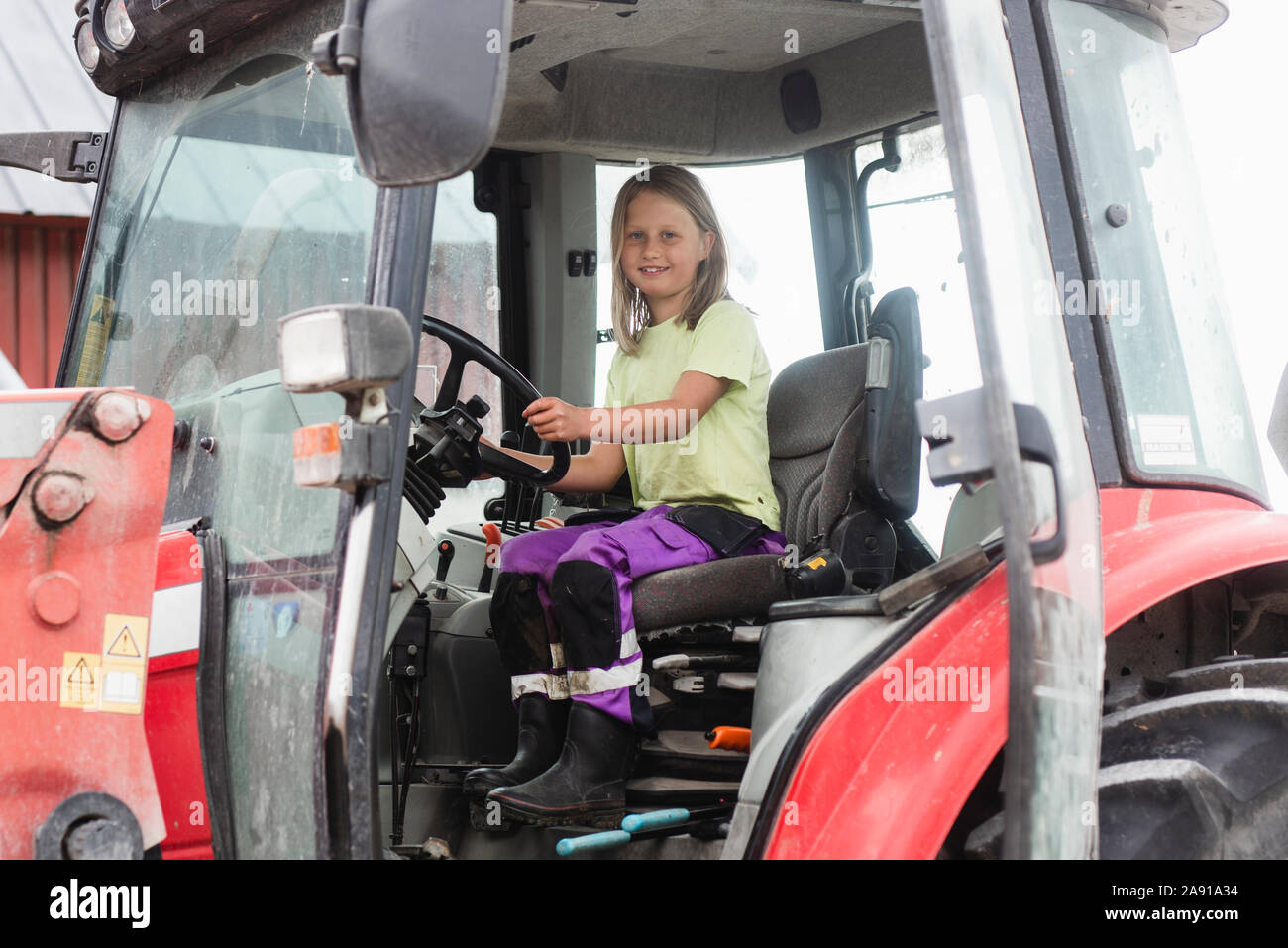Girl sitting in tractor Stock Photo - Alamy