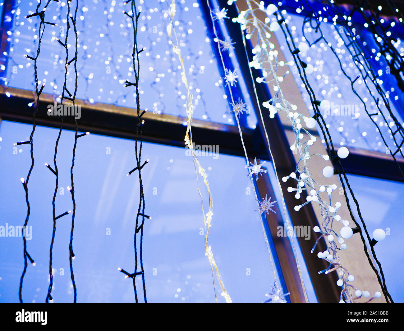 Garlands are hanging on the window. multi-colored light bulbs garlands ...