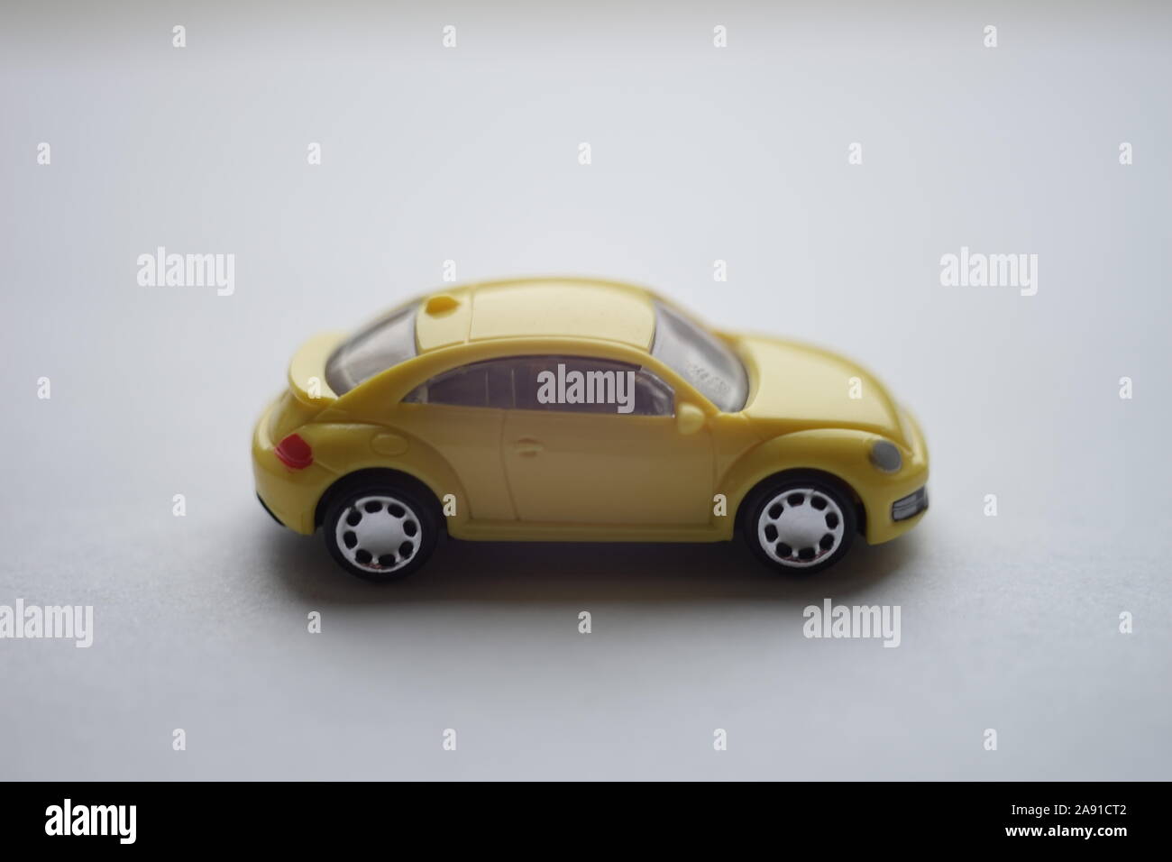 Yellow toy car on white surface, side view Stock Photo - Alamy