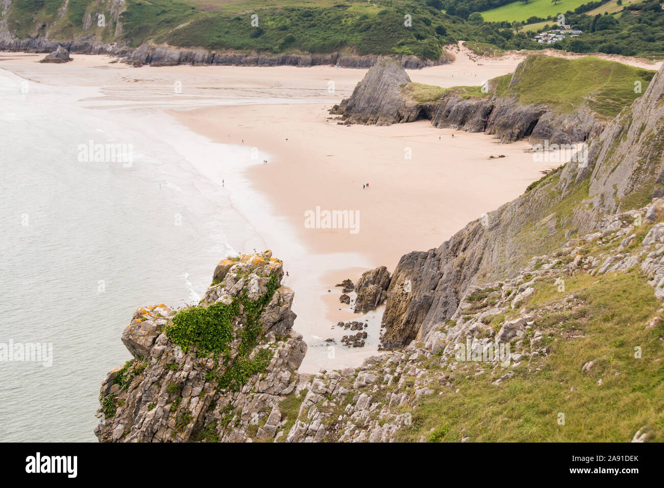 On a cliff top overlooking the beach at Three Peaks Bay on the Gower ...