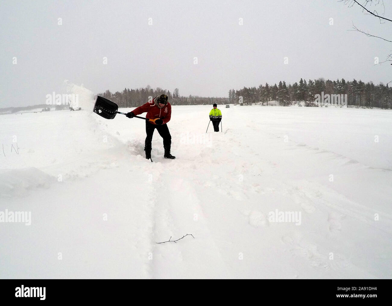 Two persons shoveling snow from rural private road Stock Photo - Alamy