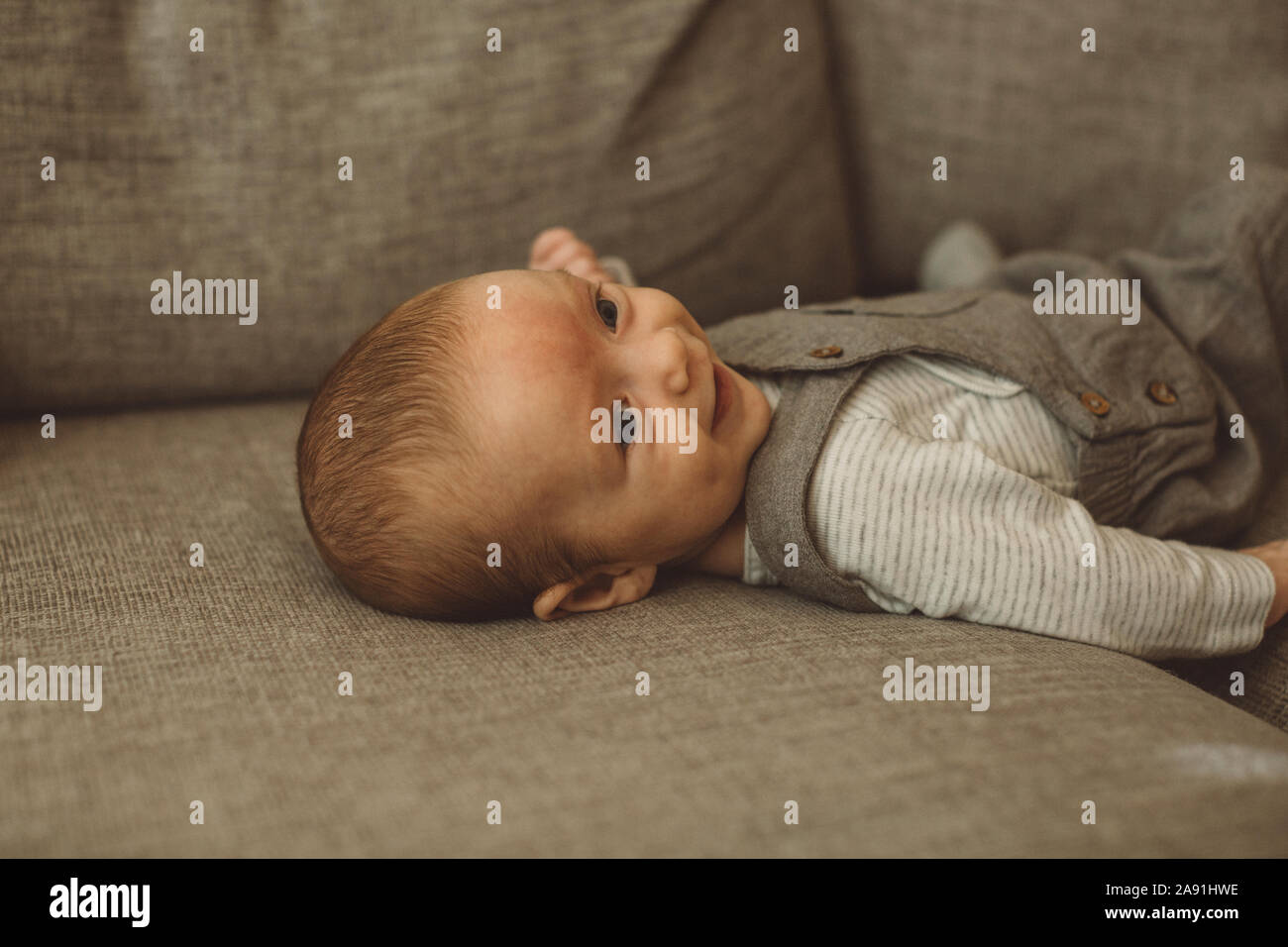 Happy baby smiling on sofa hi-res stock photography and images - Alamy