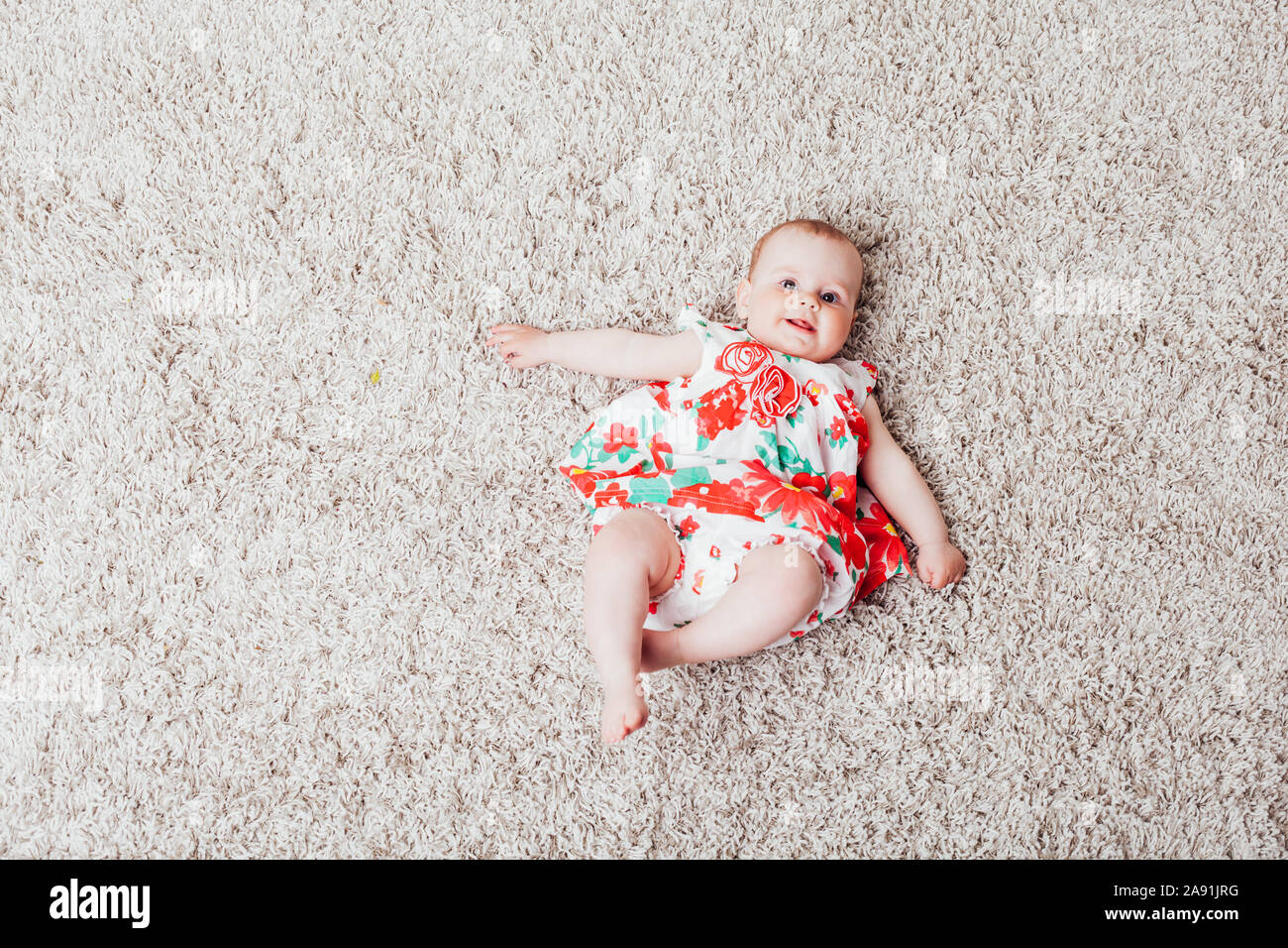 baby girl in a dress with red flowers Stock Photo - Alamy