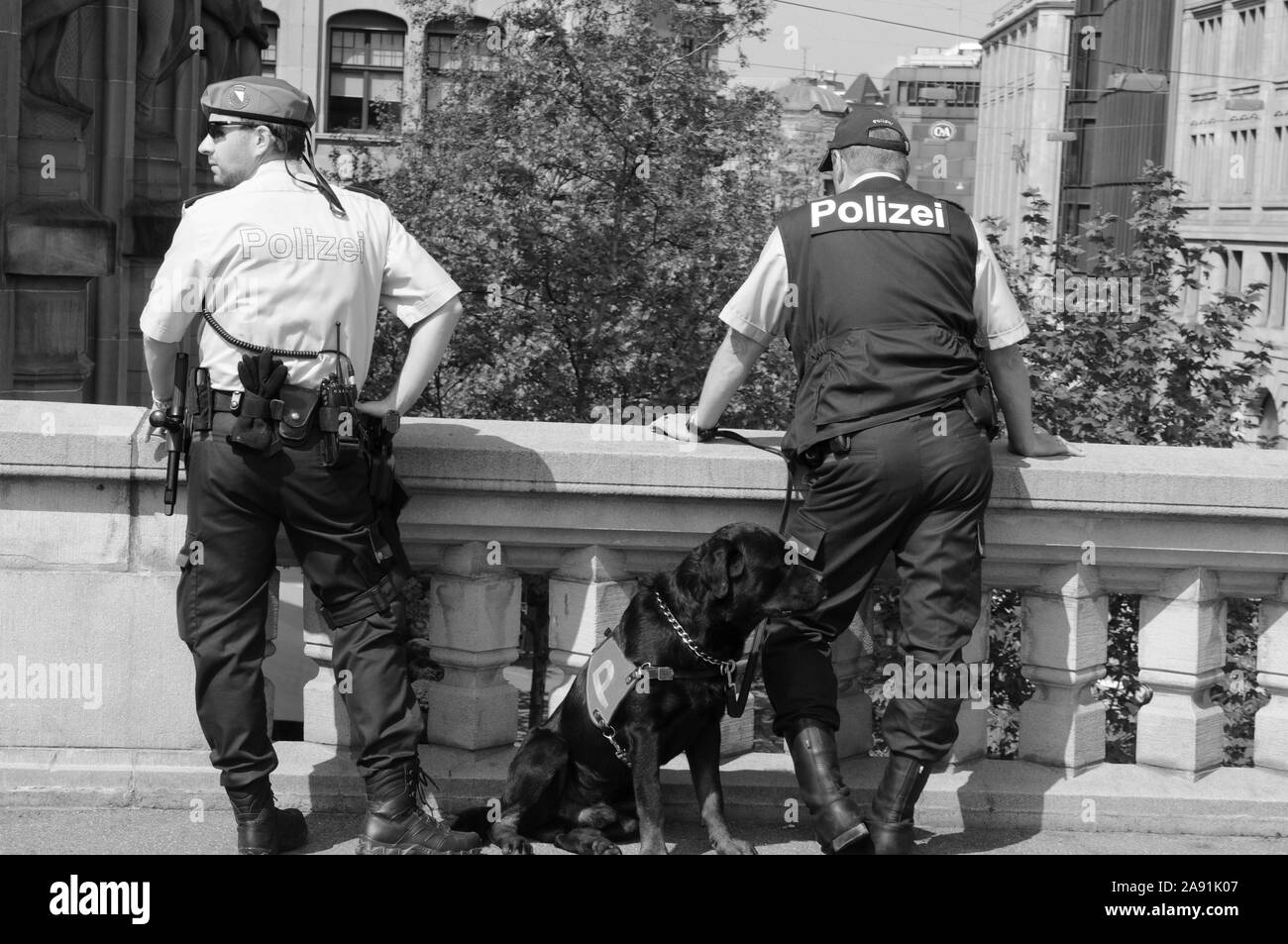 Switzerland: Two police men with a police dog obeying the demonstration ...