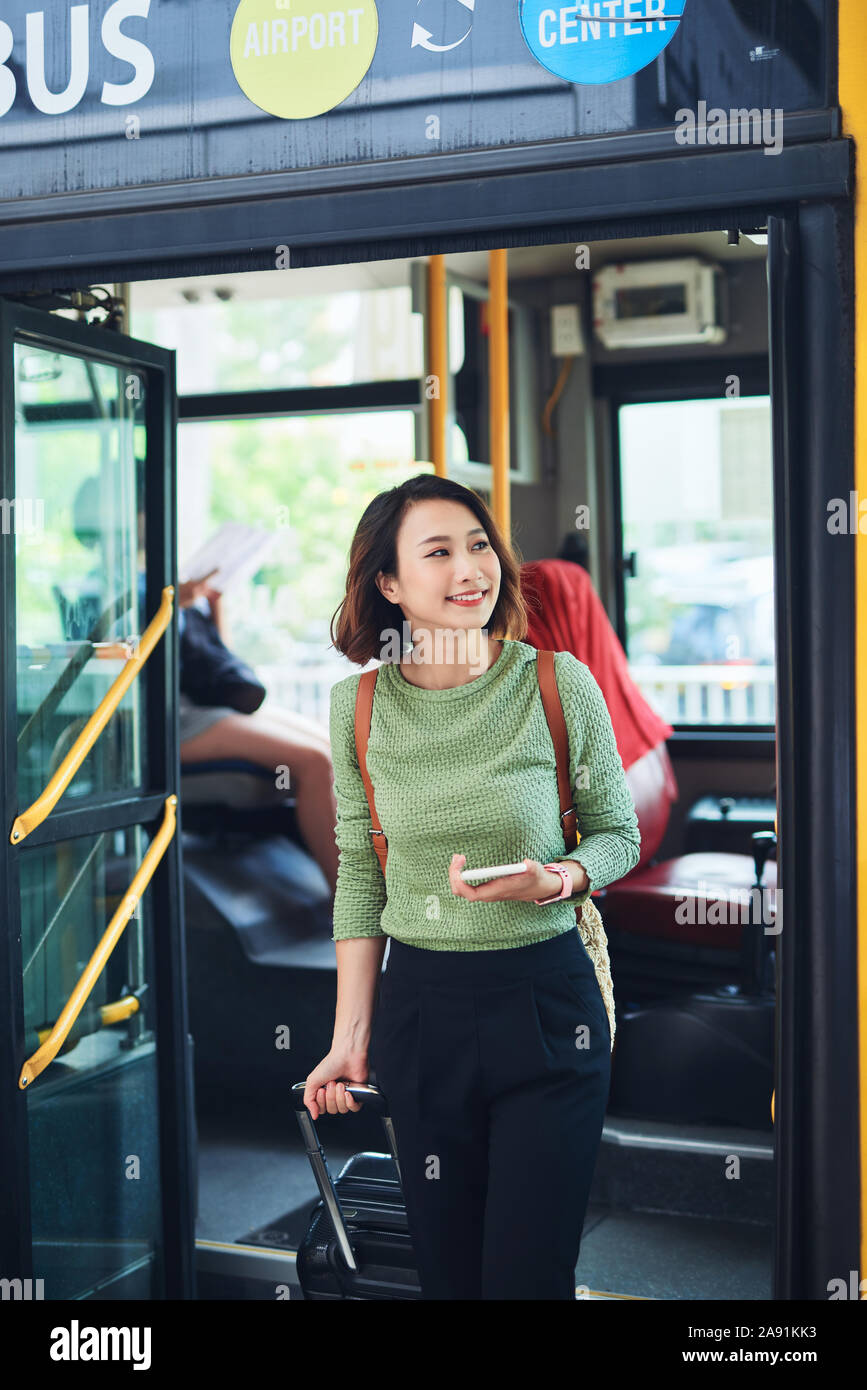 Female traveler going off the bus at terminal Stock Photo - Alamy