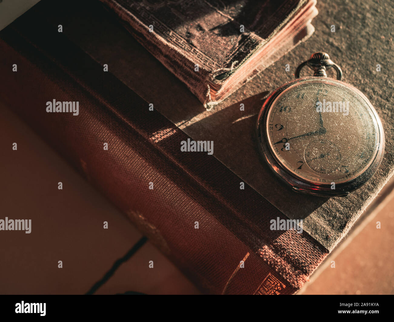 Old pocket watch on book Stock Photo - Alamy