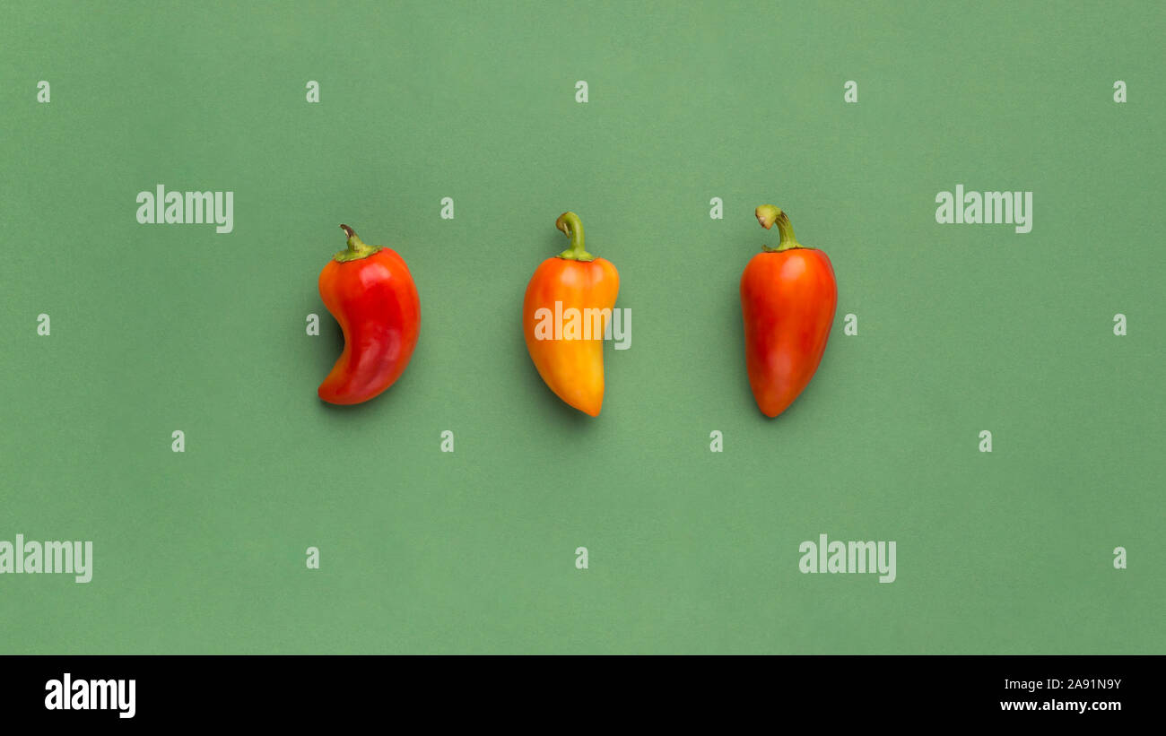 Three Bright peppers on light green background Stock Photo - Alamy