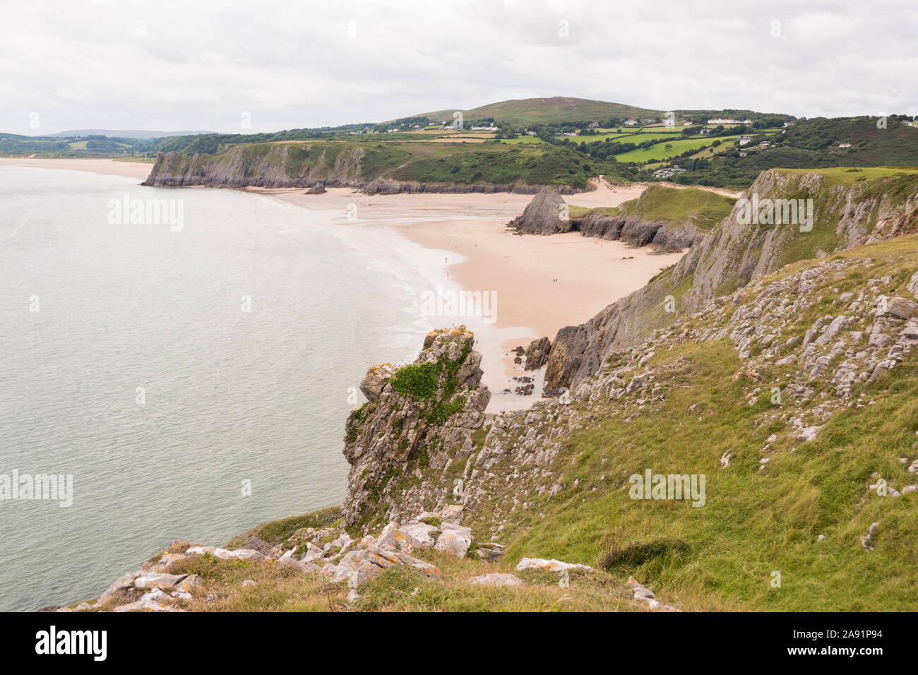 On a cliff top overlooking the beach at Three Peaks Bay on the Gower ...