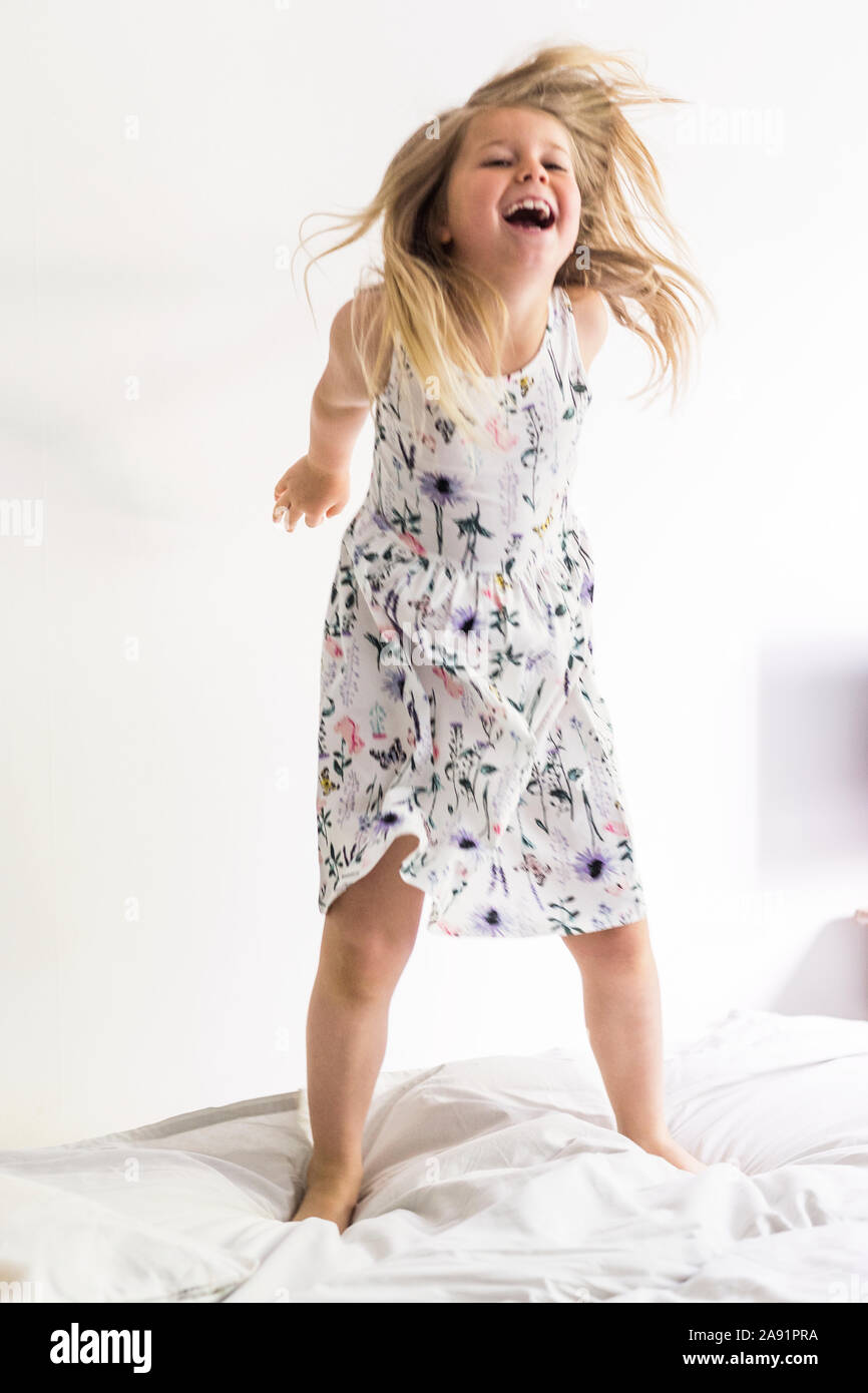 Happy girl jumping on bed Stock Photo - Alamy
