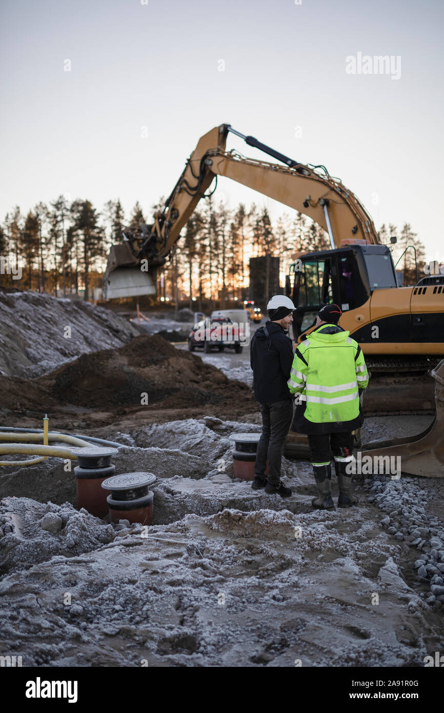 People at work near digger Stock Photo - Alamy