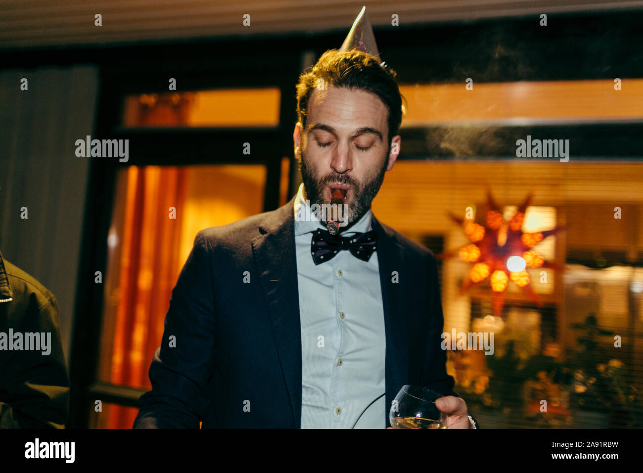 Man smoking cigar at party Stock Photo - Alamy