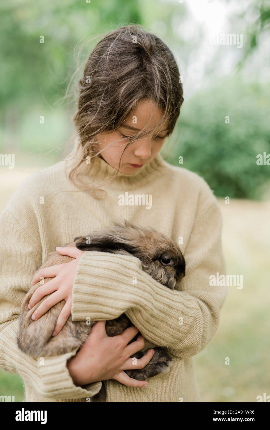 Girl holding rabbit Stock Photo - Alamy