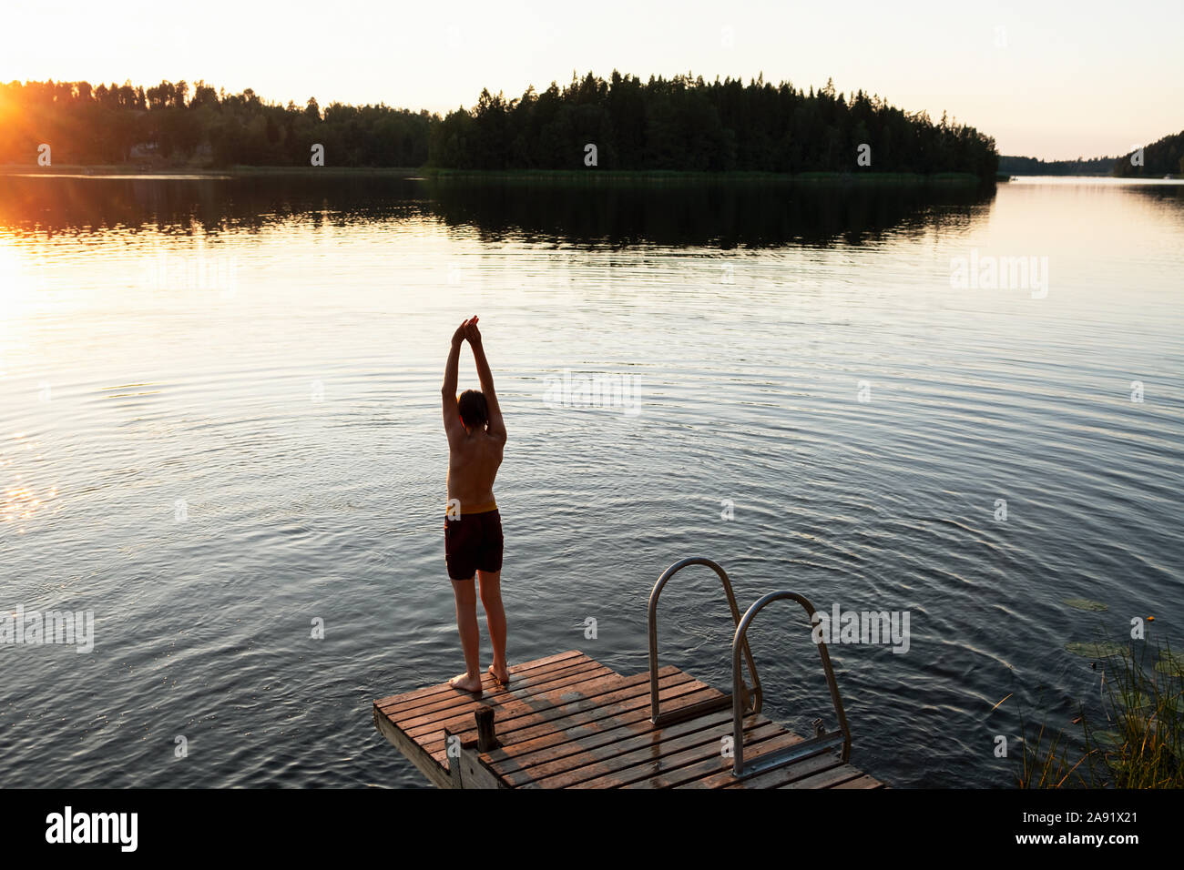 Boy on jetty Stock Photo - Alamy