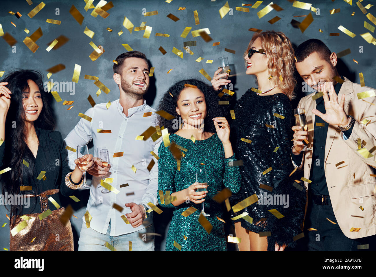 Happy young people dancing and having fun with confetti flying ...