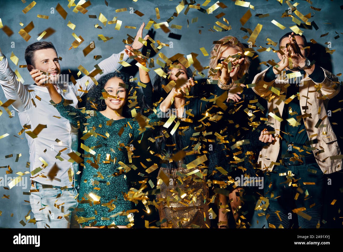 Happy young people dancing and having fun with confetti flying ...