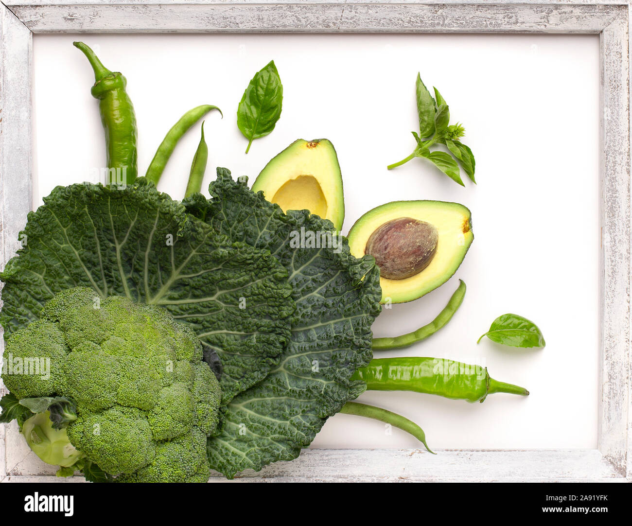 Green fresh vegetables inside frame on white background Stock Photo - Alamy