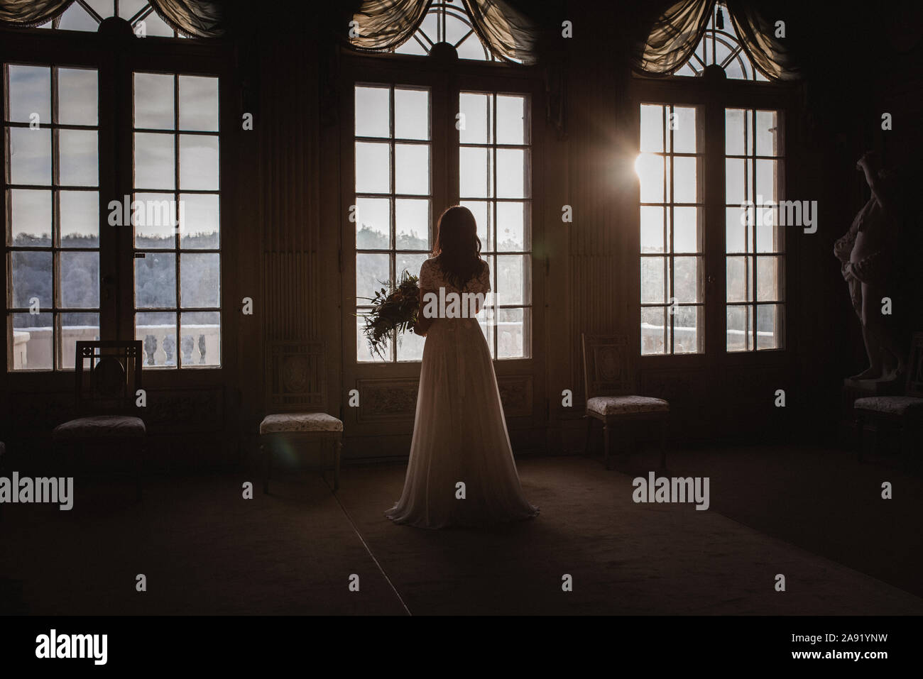 Bride looking through window Stock Photo - Alamy
