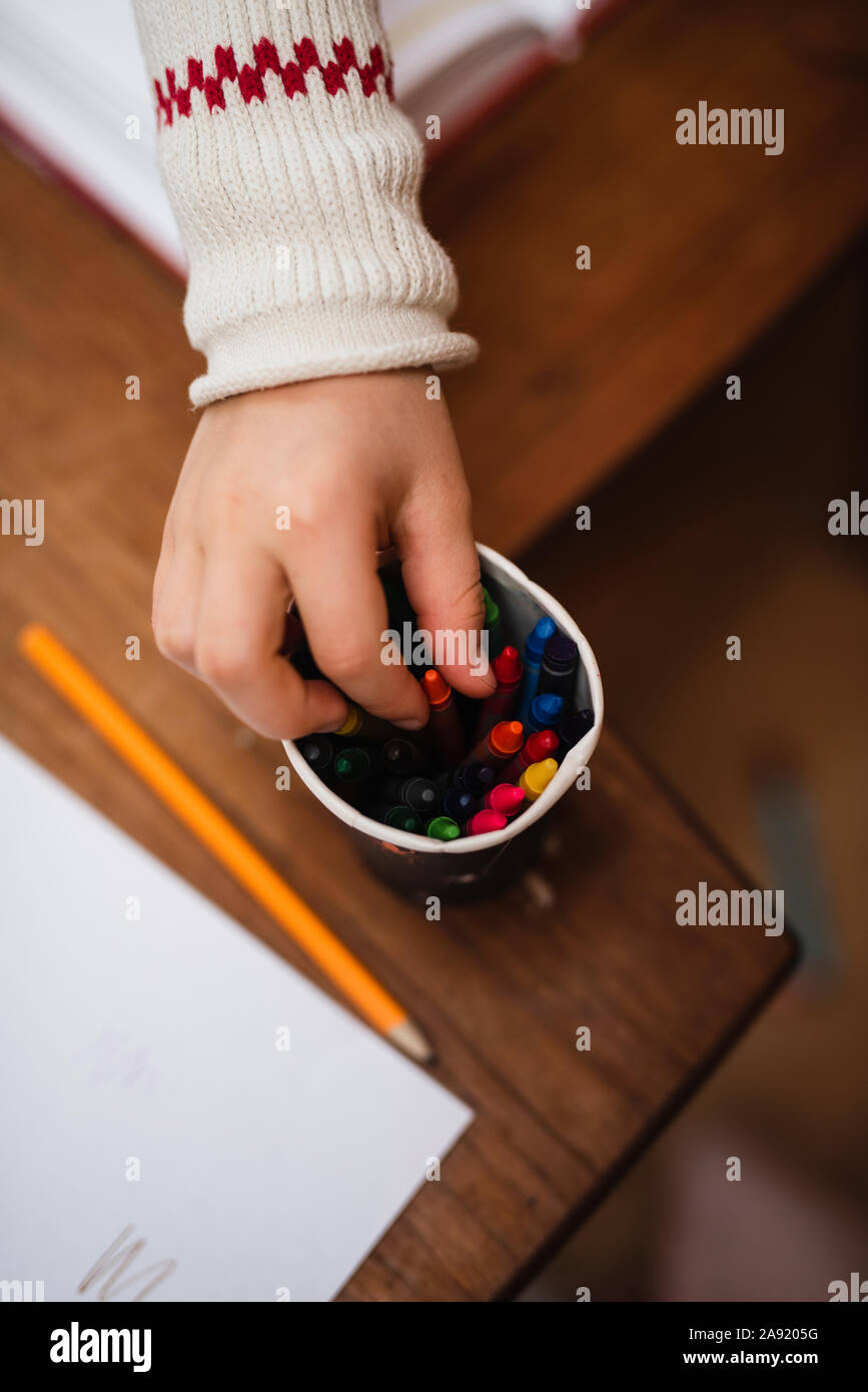 Childs hand choosing crayon Stock Photo - Alamy