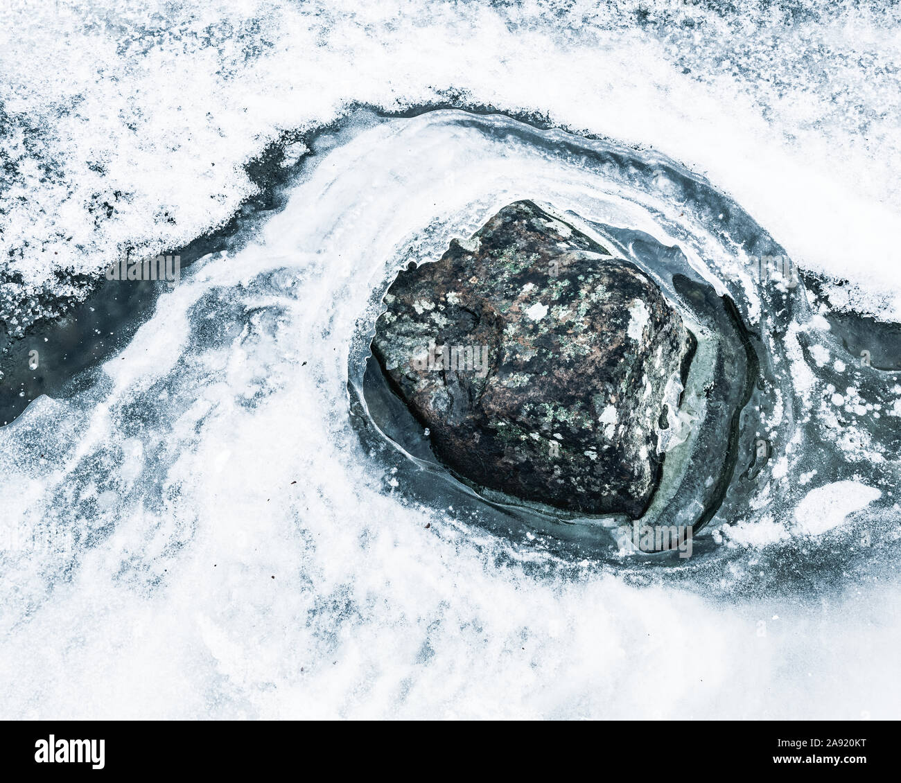Ice around rock Stock Photo - Alamy