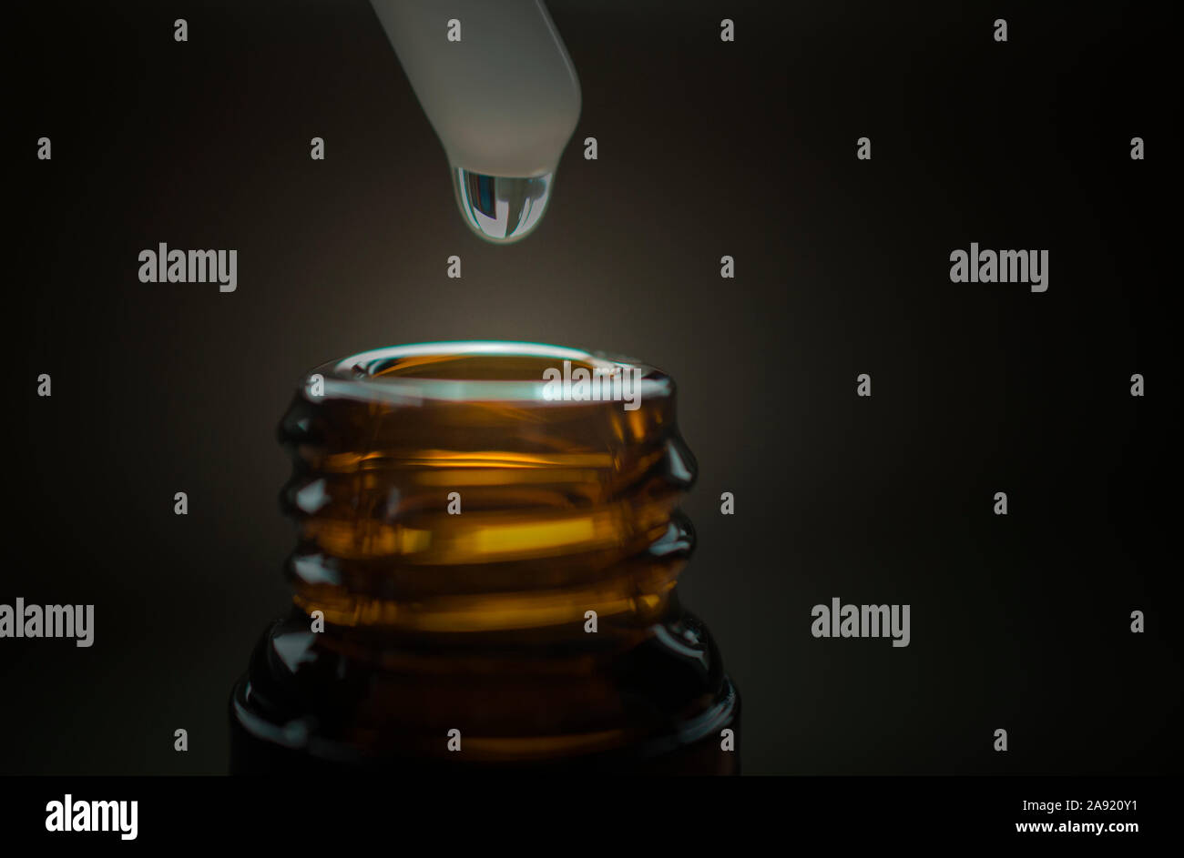 A pipette / dropper dispensing a drop of solution / medicine / vitamin ...