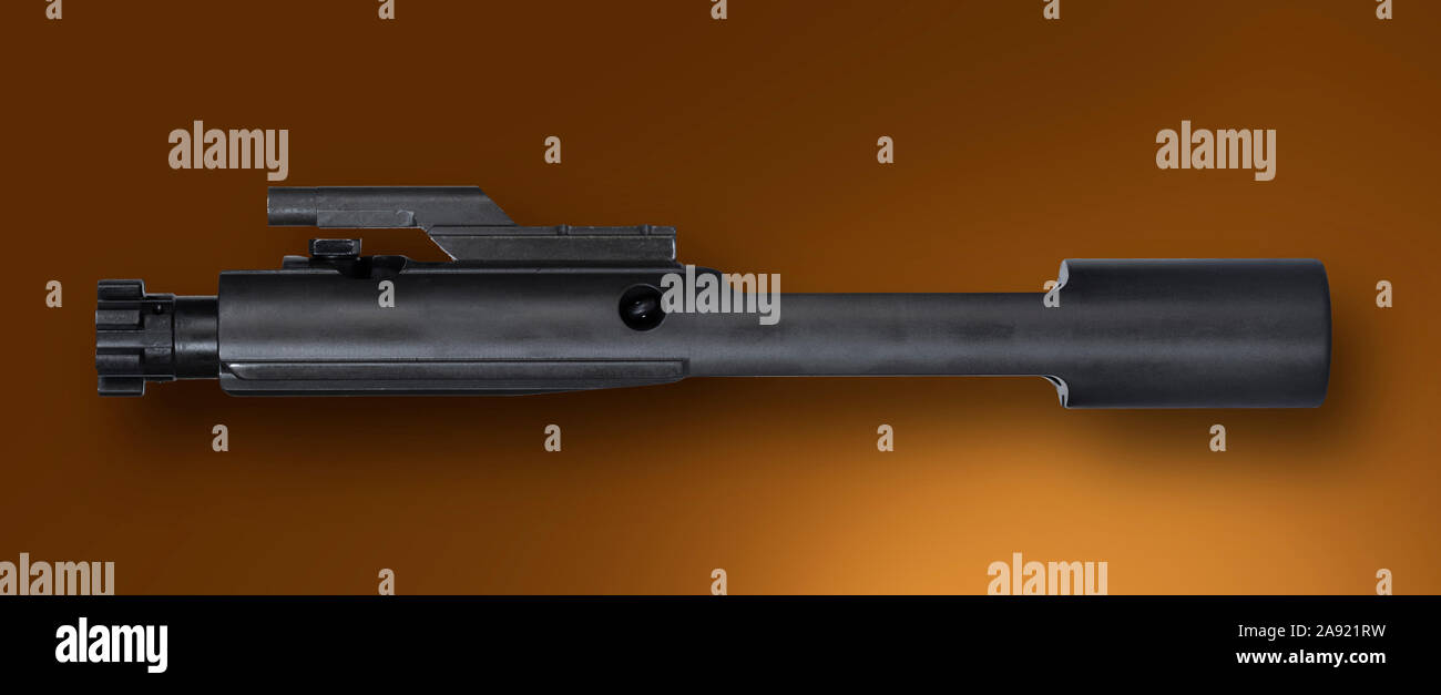 Assault rifle bolt carrier group on a brown background with a drop ...
