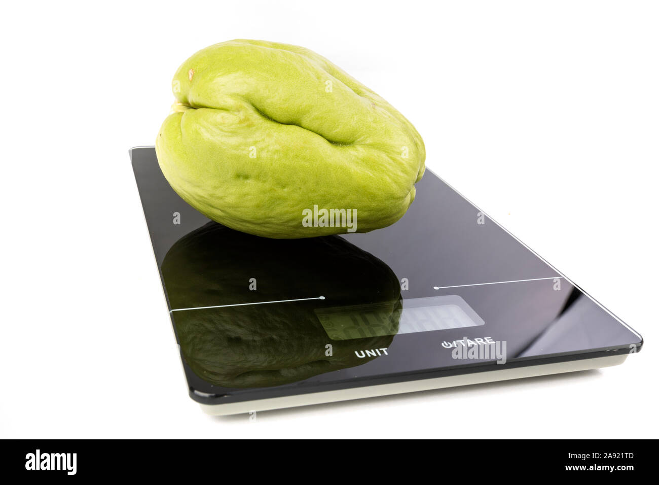 One raw whole ripe green chayote mexican squash on a scale Stock Photo ...