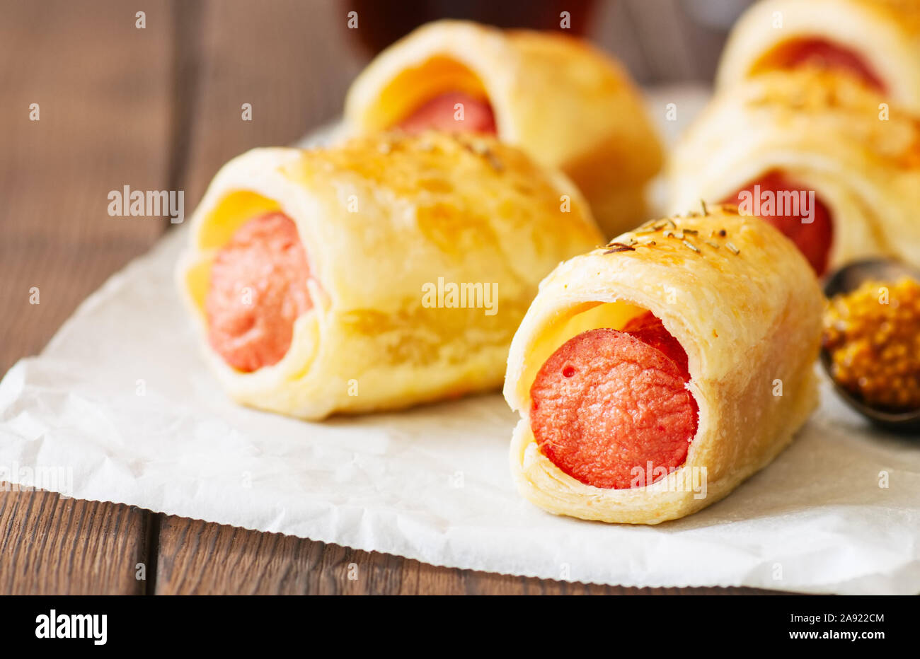 Pigs in a planket - puff pastry rolls with sausages on a wooden ...