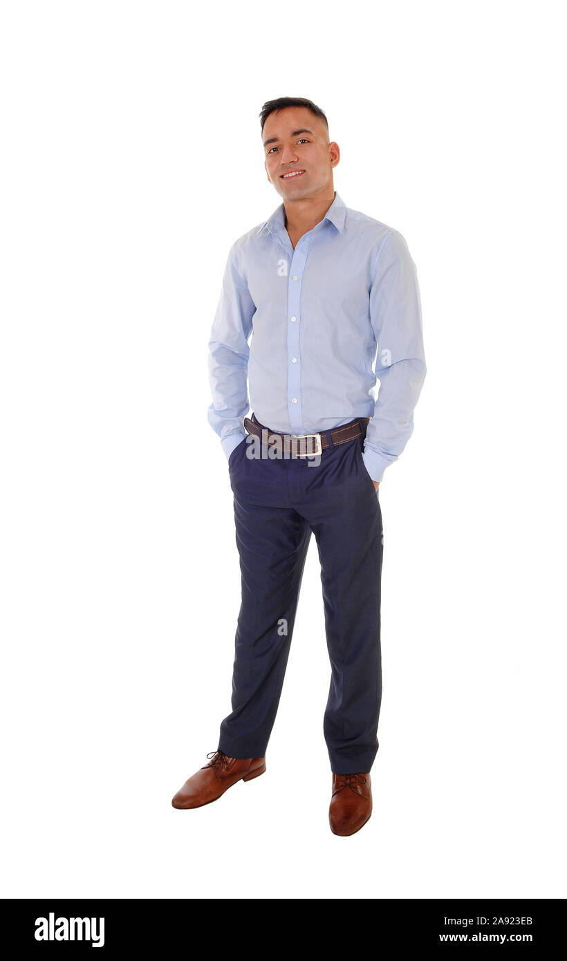 A handsome east Indian man standing in dress pants and a blue shirt ...